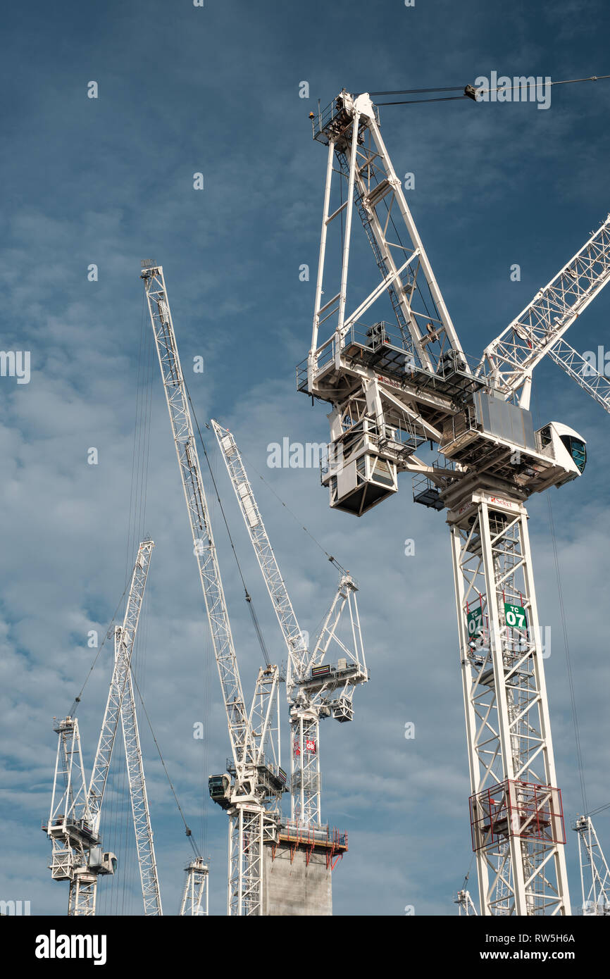 Large white construction cranes towering above a construction site in ...