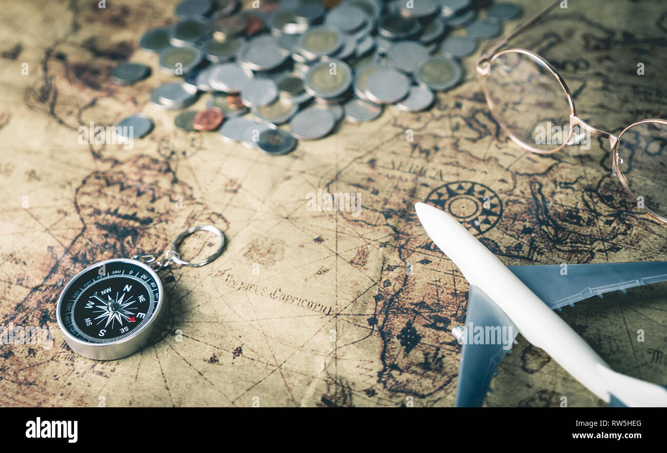 Saving money for World travel on vintage map concept Stock Photo - Alamy