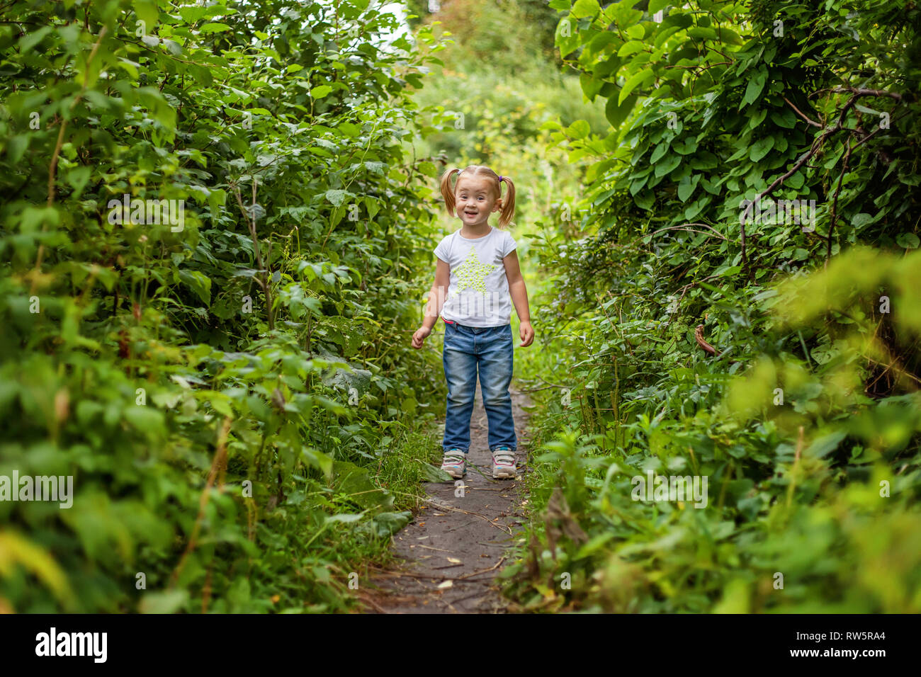 Portrait of happy cute little girl outdoor. Kid palying in park, garden ...