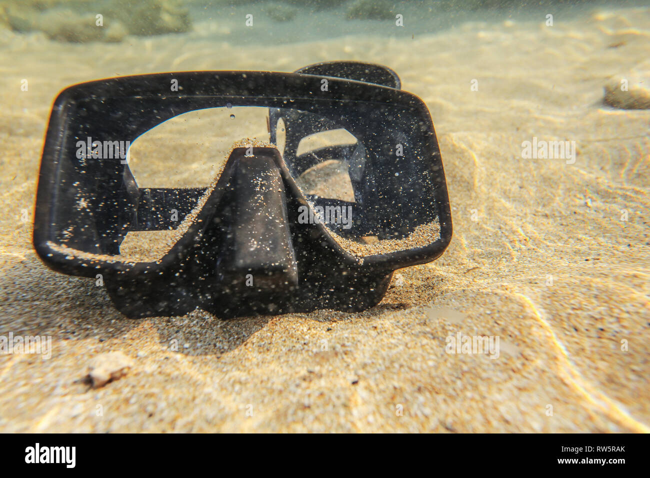 Underwater photo - black diving mask / goggles on sand in shallow water ...