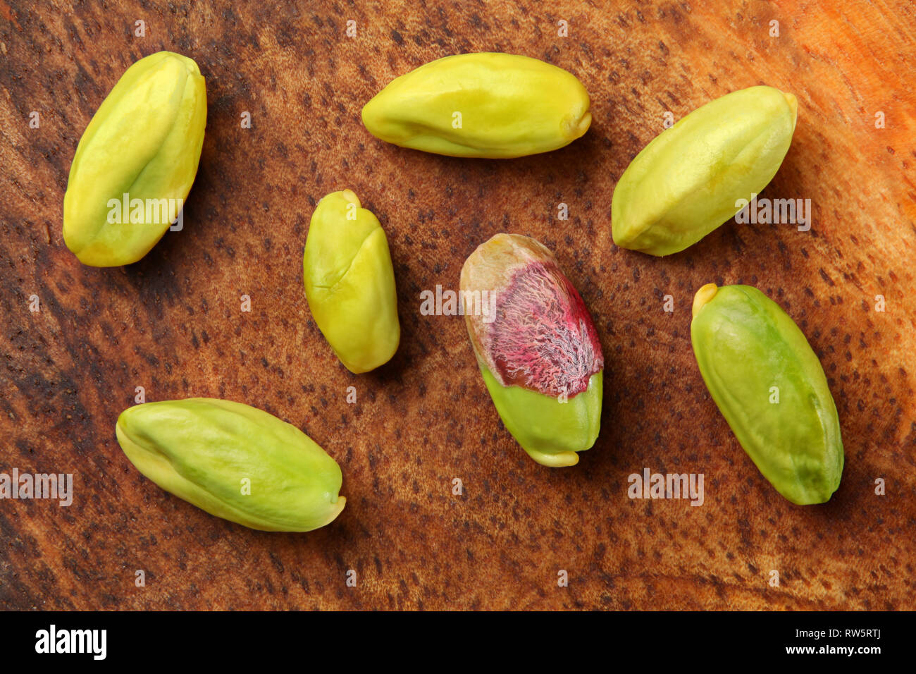 Top down view, green peeled pistachio nuts on wooden board Stock Photo ...