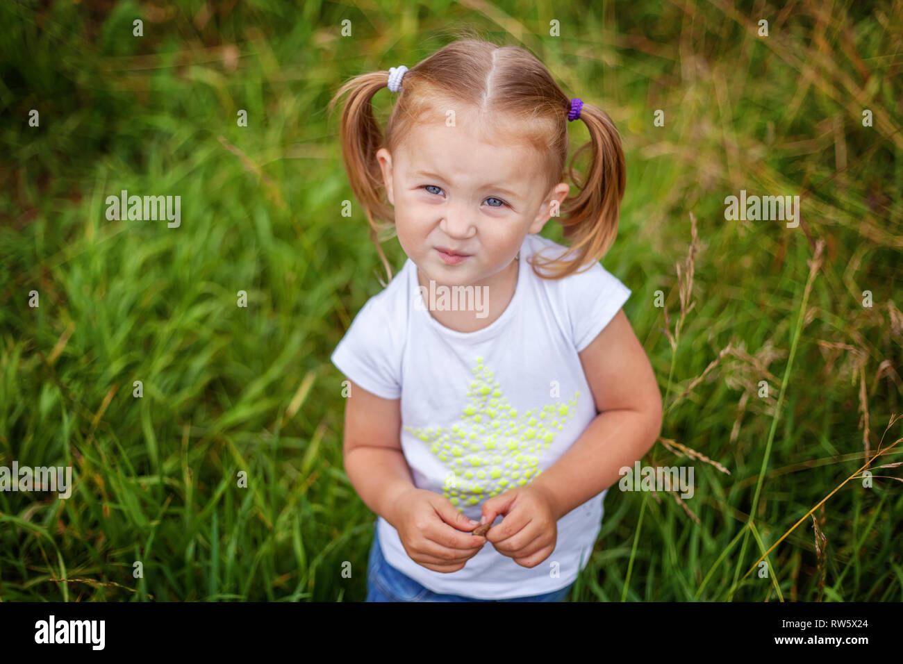 Portrait of happy cute little girl outdoor. Kid palying in park, garden ...
