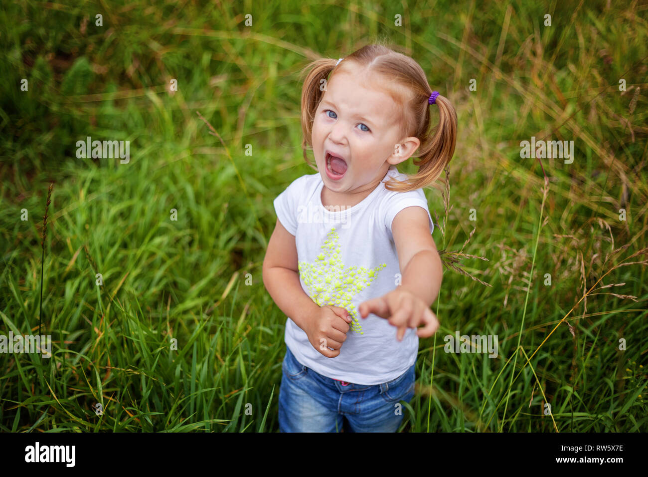 Portrait of happy cute little girl outdoor. Kid palying in park, garden ...
