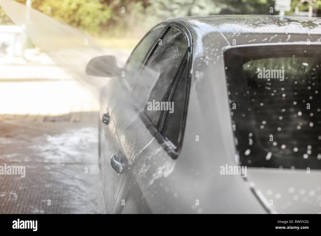 Car washed in self serve carwash, jet stream of water spraying on the ...
