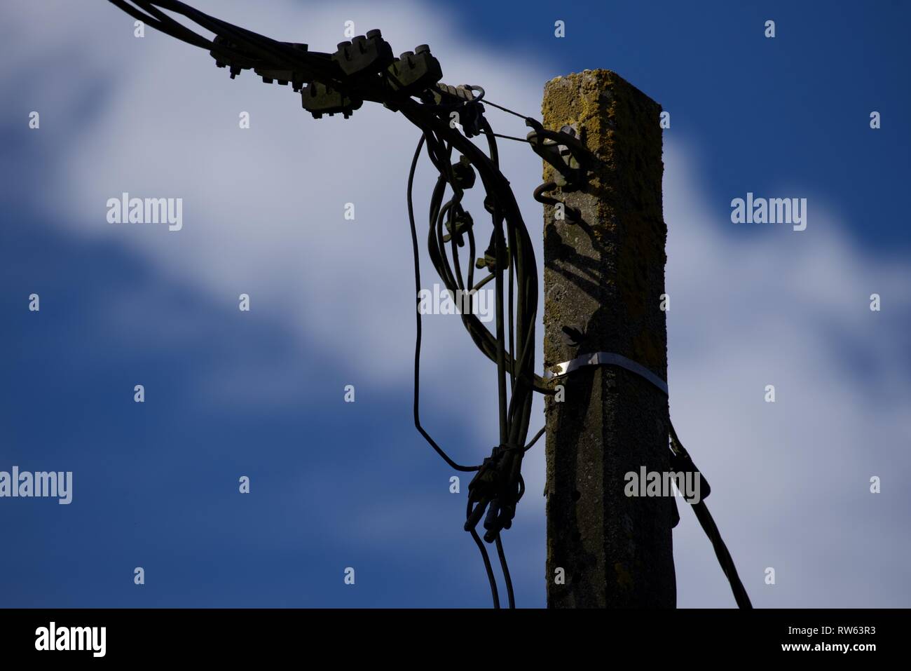 Electricity: overground power supply cables attached to a concrete post ...