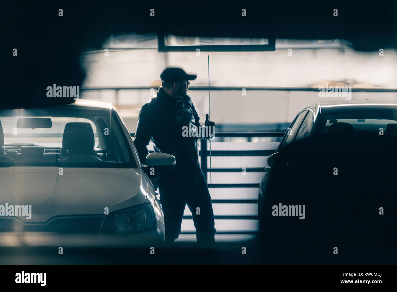 Masked man is robbing a car with wrecking bar Stock Photo - Alamy