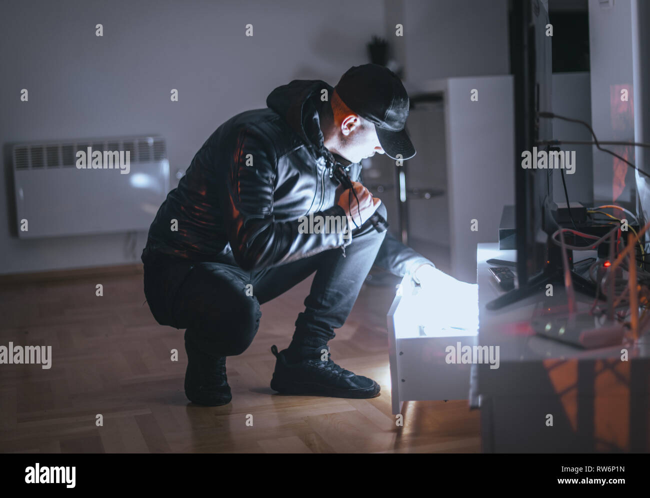 Burglary man stealing gold while looking with torch Stock Photo - Alamy