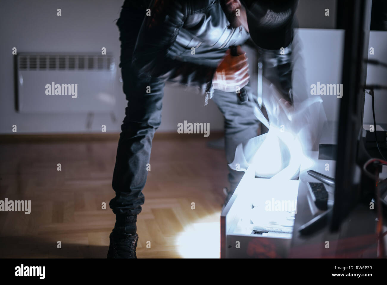Robbery man in dark room stealing documents from desk Stock Photo - Alamy