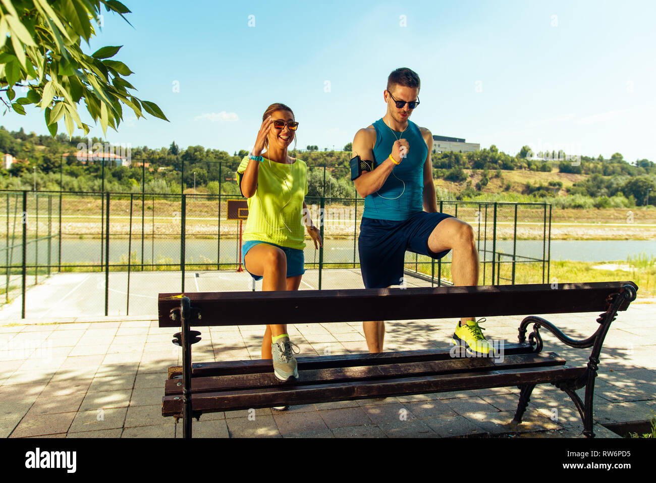 Young couple exercising and stretching muscles before sport activity ...