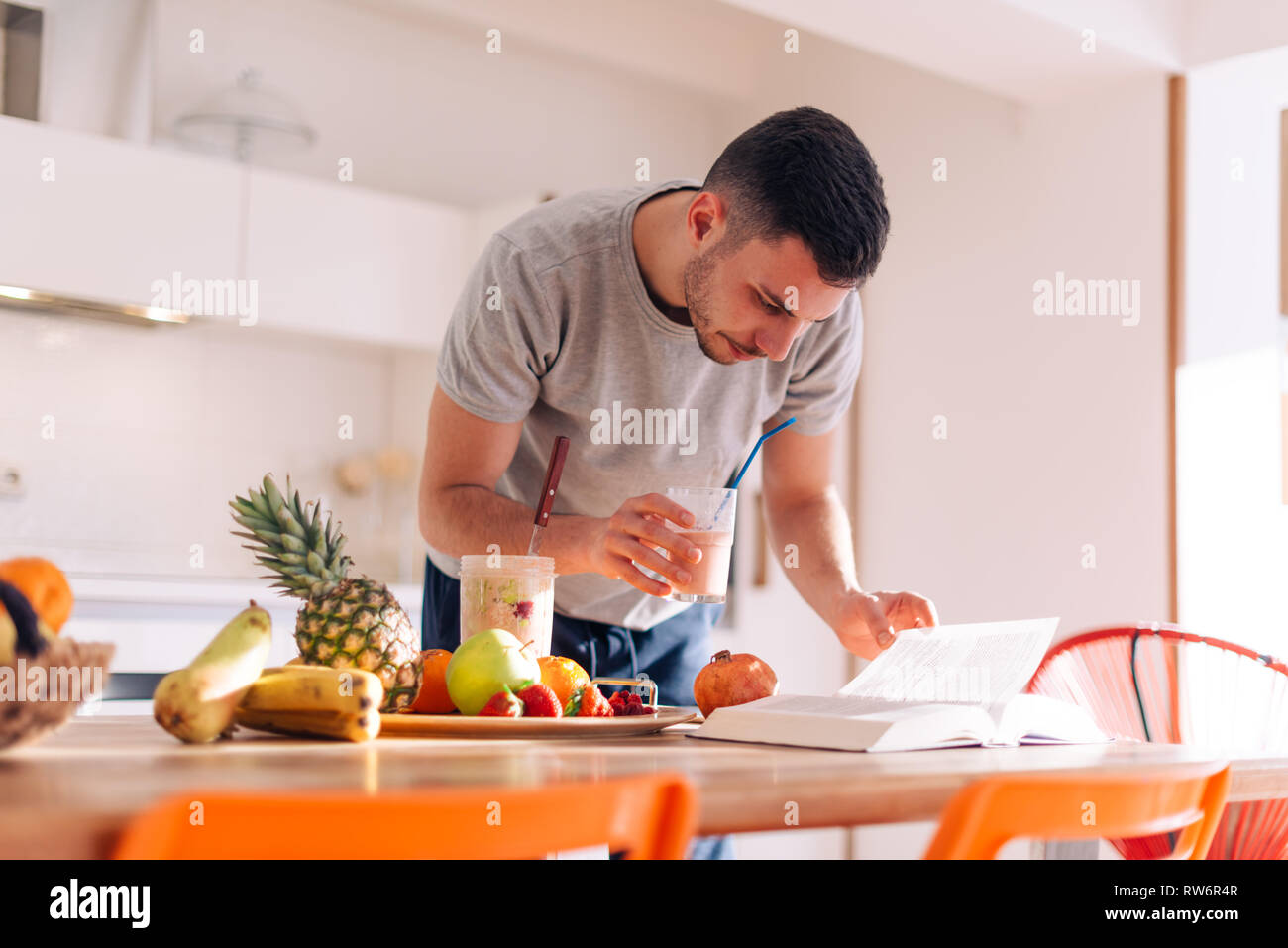 healthy strong young man reading a book early in the morning while ...