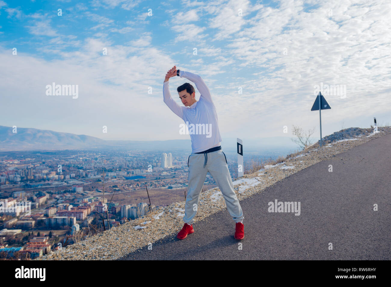 Fit male stretching and performing his morning routines while wearing a ...