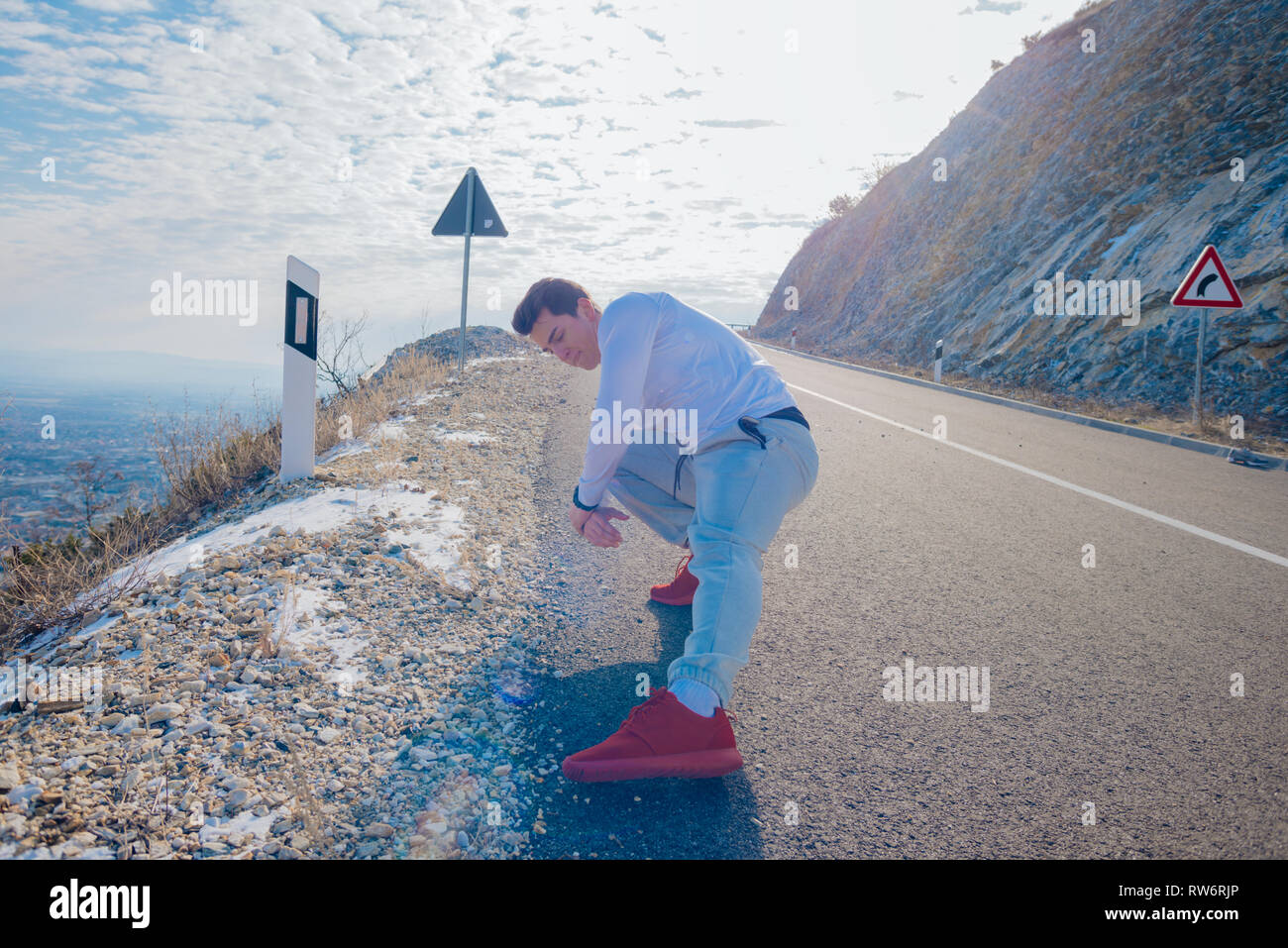 Bodybuilder performing his stretching routine in the morning on an ...