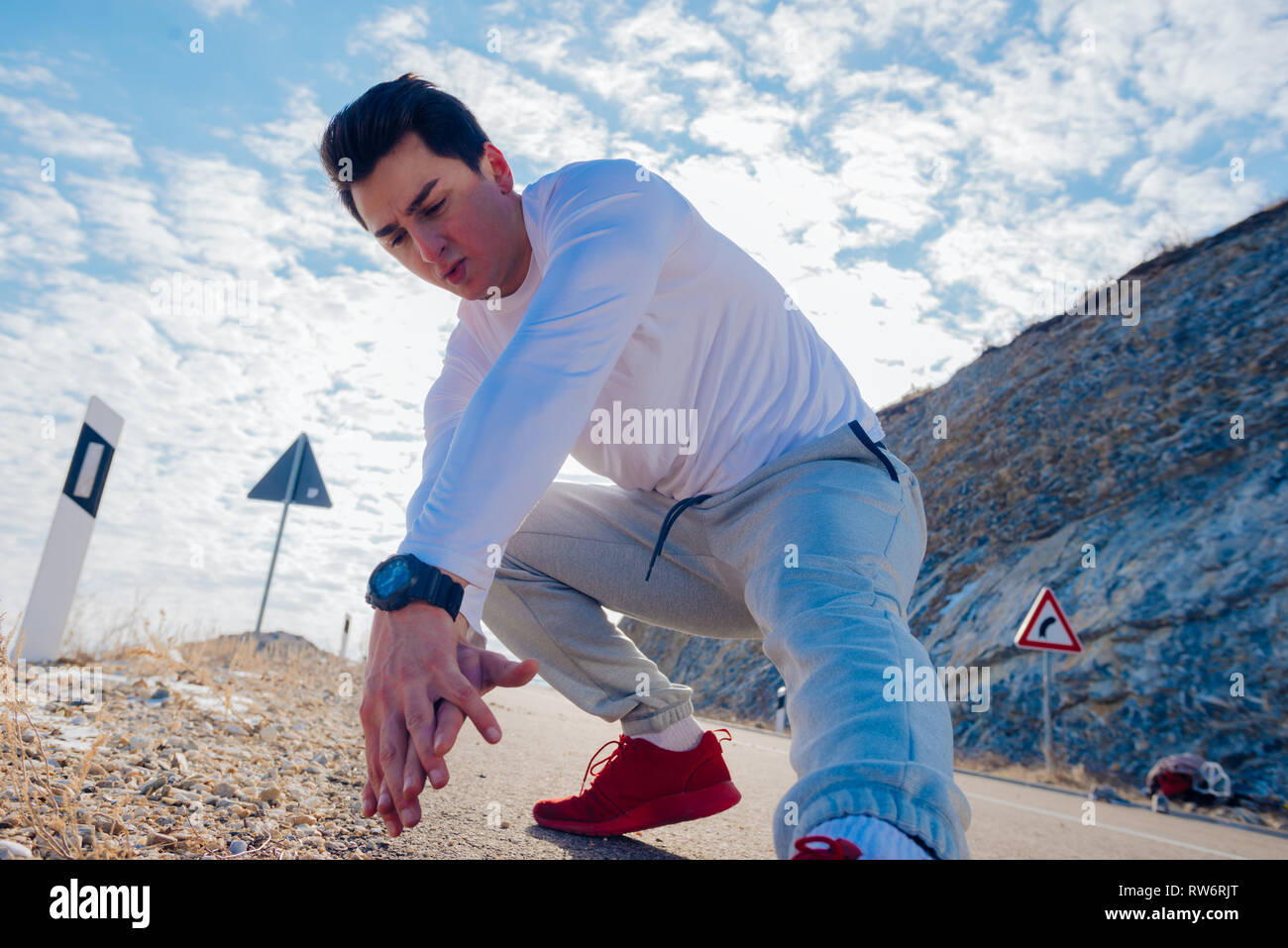 Bodybuilder performing his stretching routine in the morning on an ...