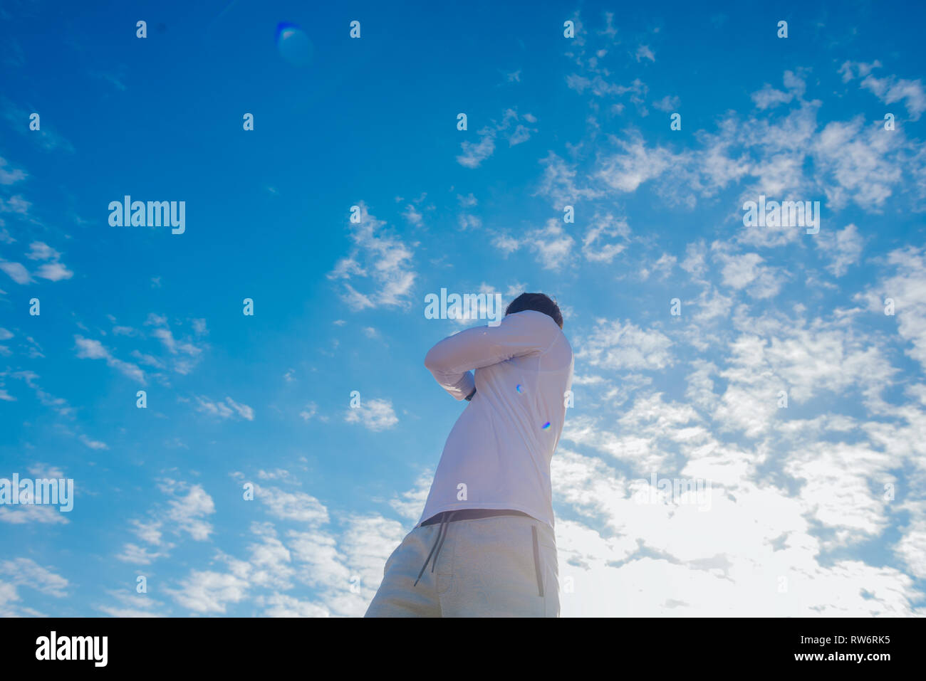 Bodybuilder performing his stretching routine in the morning on an ...