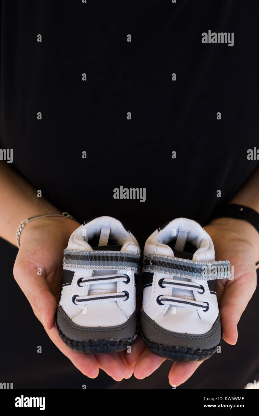 Little baby shoes in hands Stock Photo - Alamy