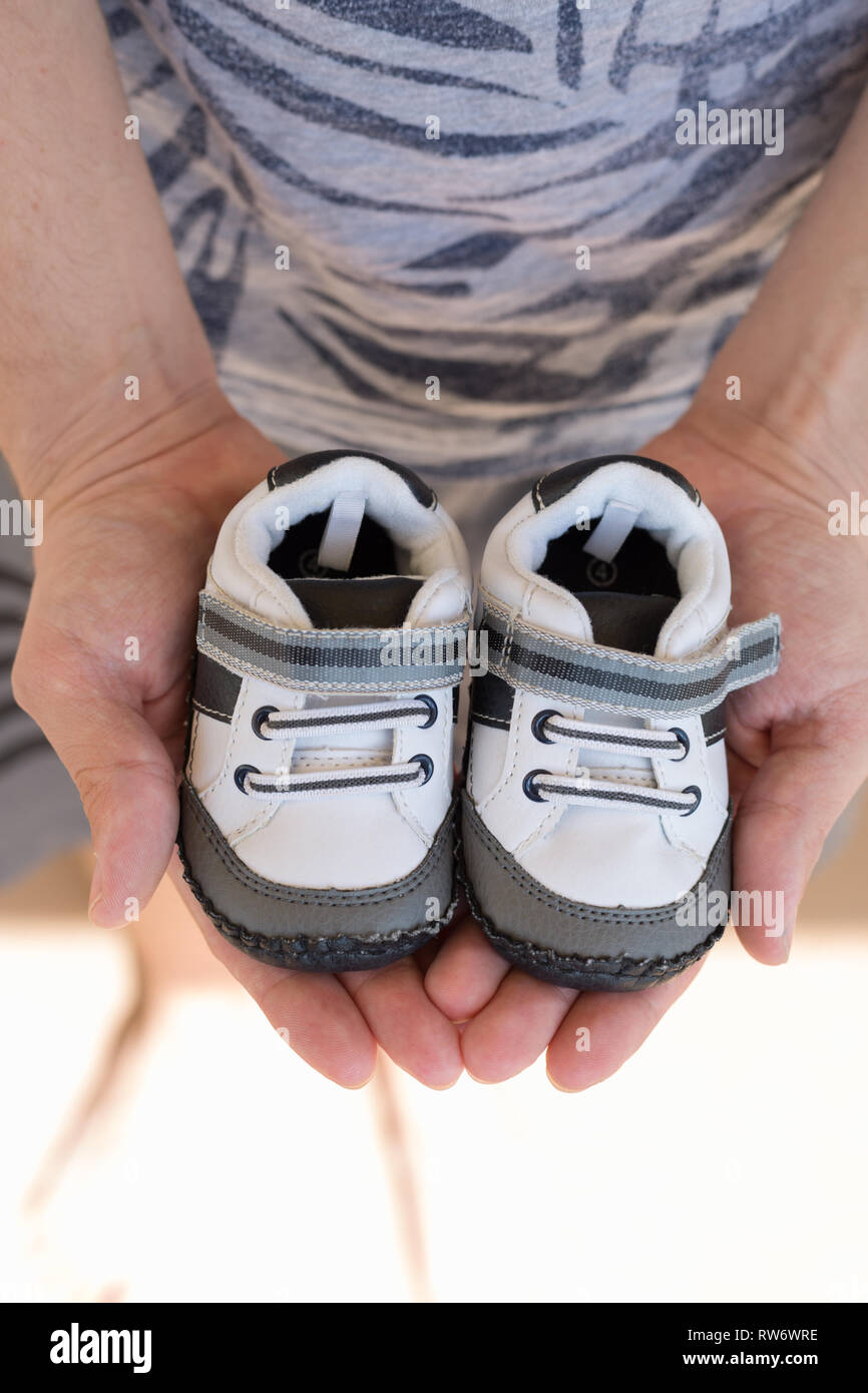 Little baby shoes in hands Stock Photo - Alamy