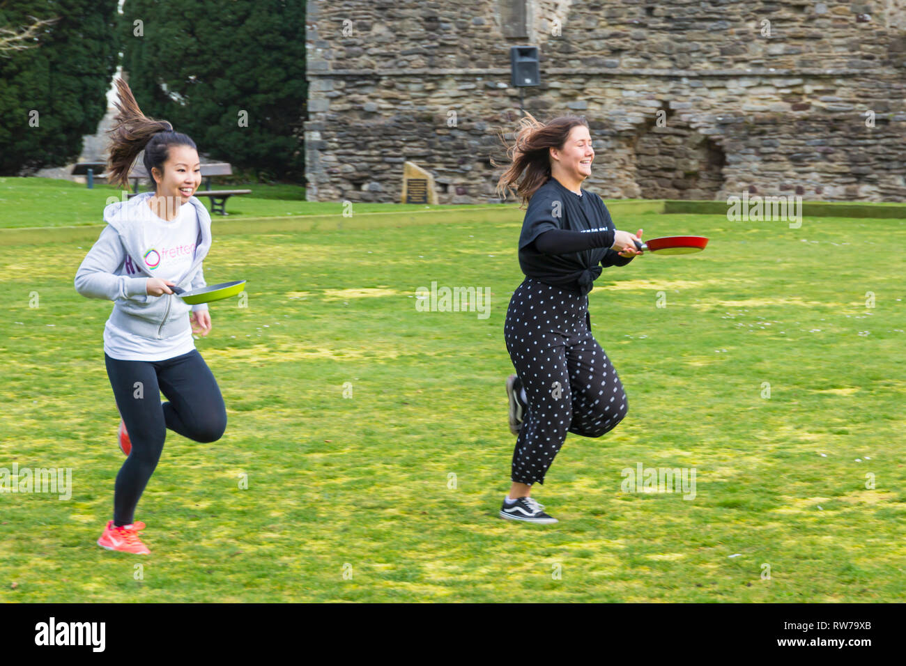 Young women running with pans hi-res stock photography and images - Alamy