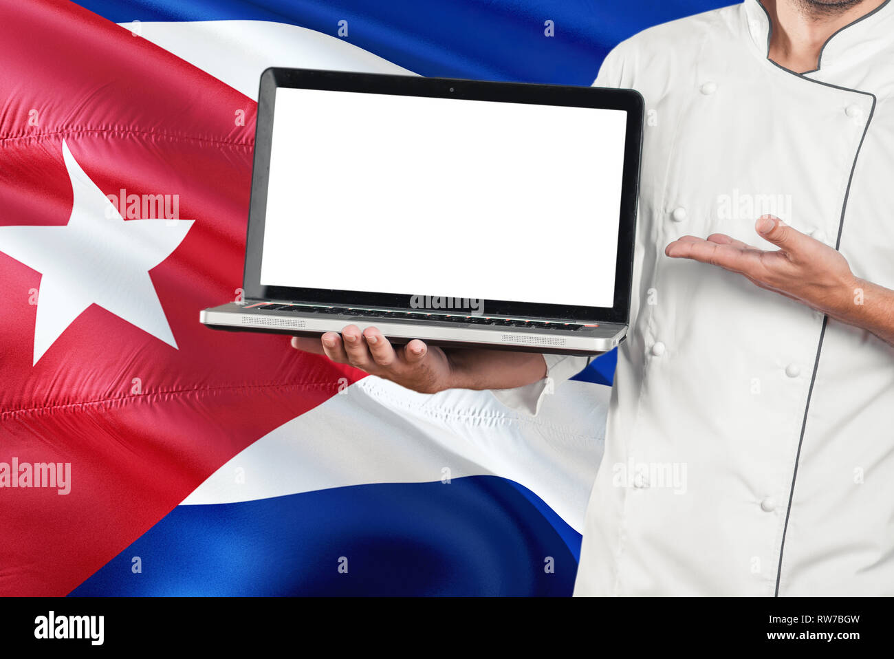 Cuban Chef holding laptop with blank screen on Cuba flag background ...