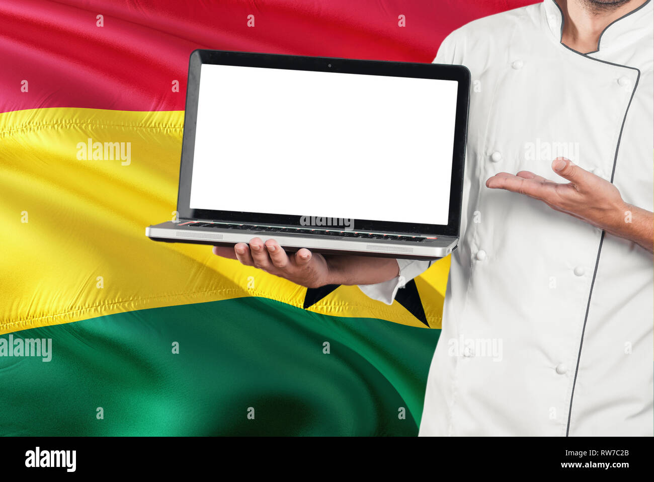 Ghanaian Chef holding laptop with blank screen on Ghana flag background ...