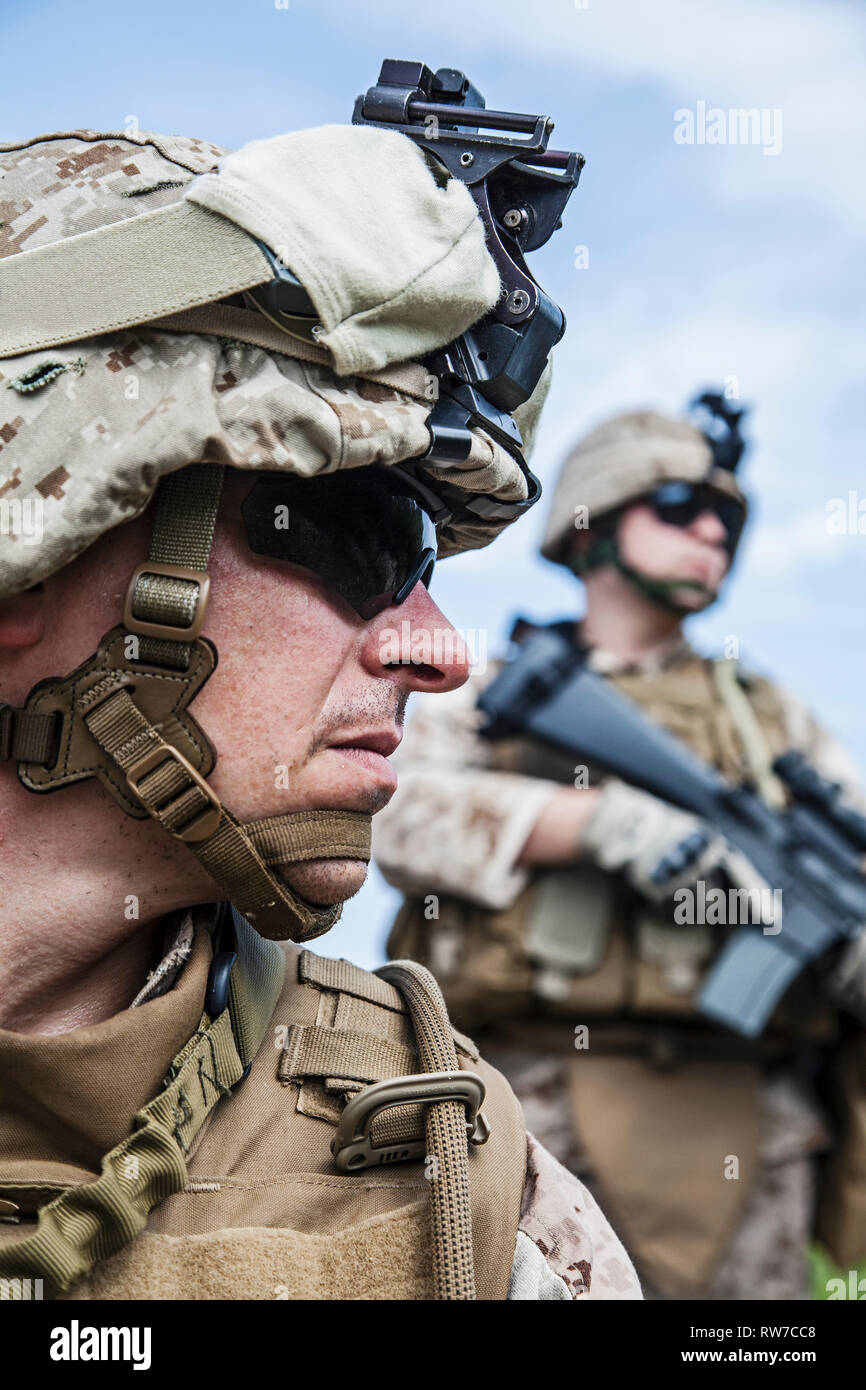 U.S. Marine half-turned to the camera. His brother-soldier looking in ...