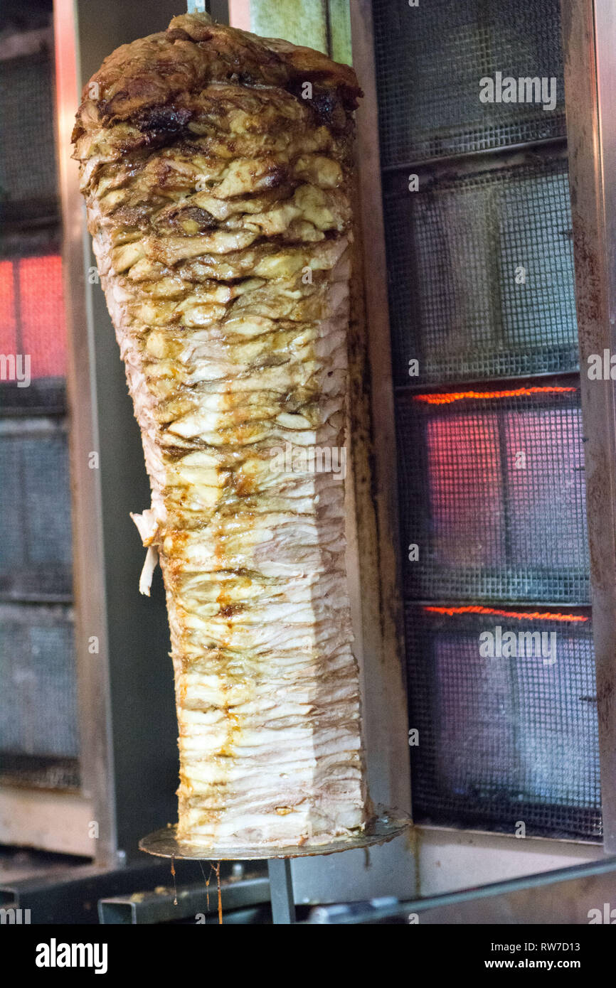 Doner meat on spit cooking infront of gas fired burner Stock Photo - Alamy