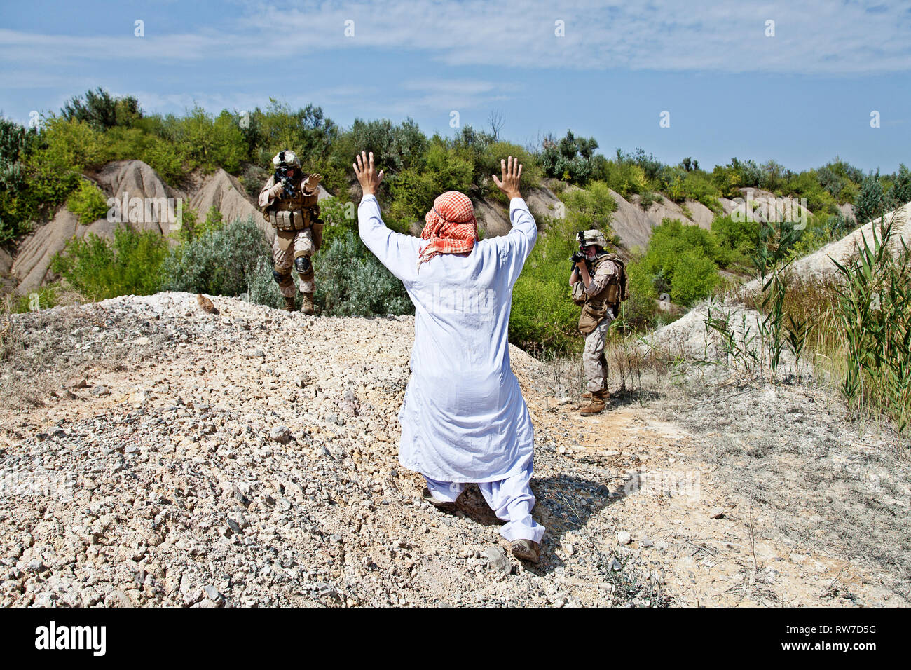 Two soldiers pointing their weapons at a muslim warrior forcing him to ...