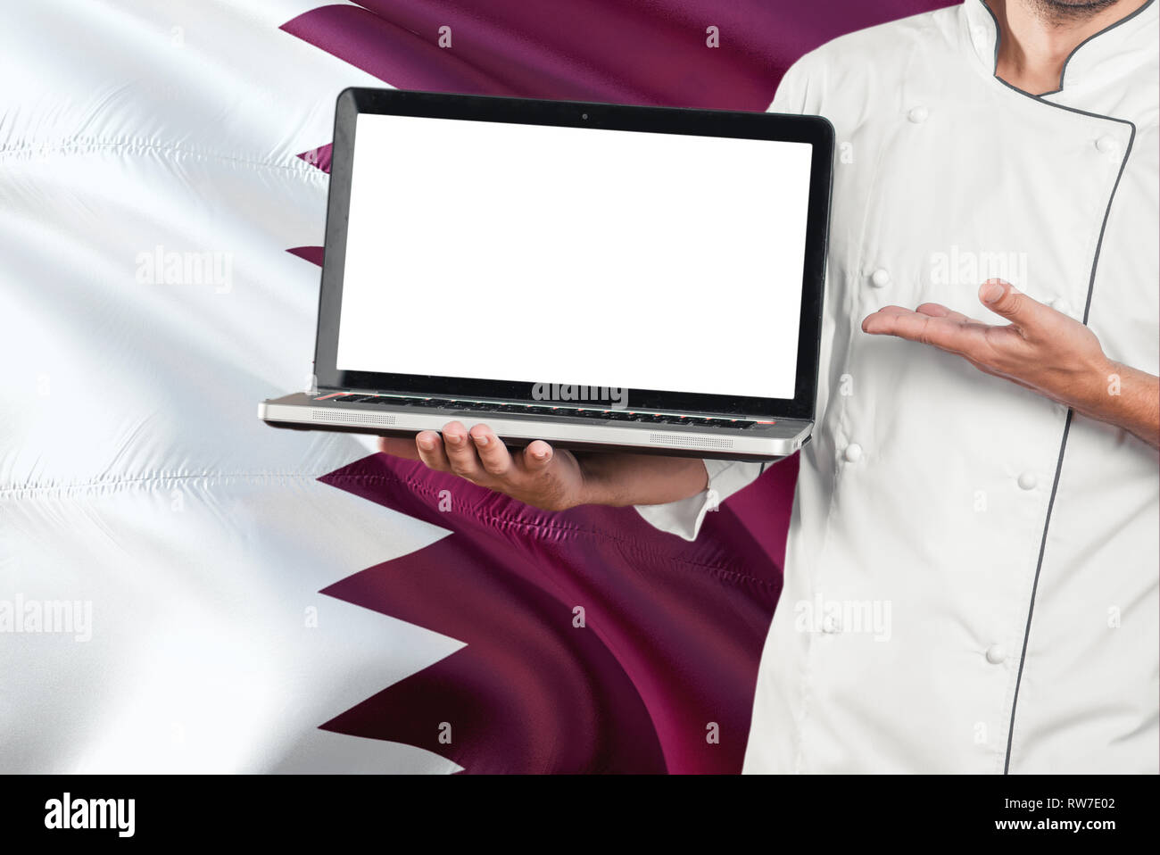 Qatari Chef holding laptop with blank screen on Qatar flag background ...