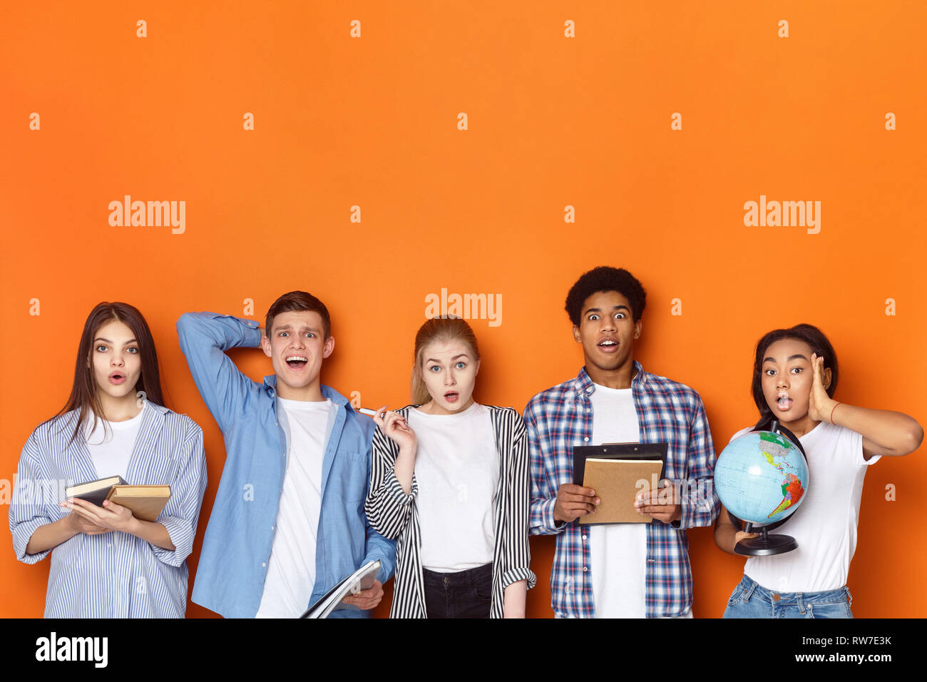 Education concept. Surprised students looking at camera over background ...