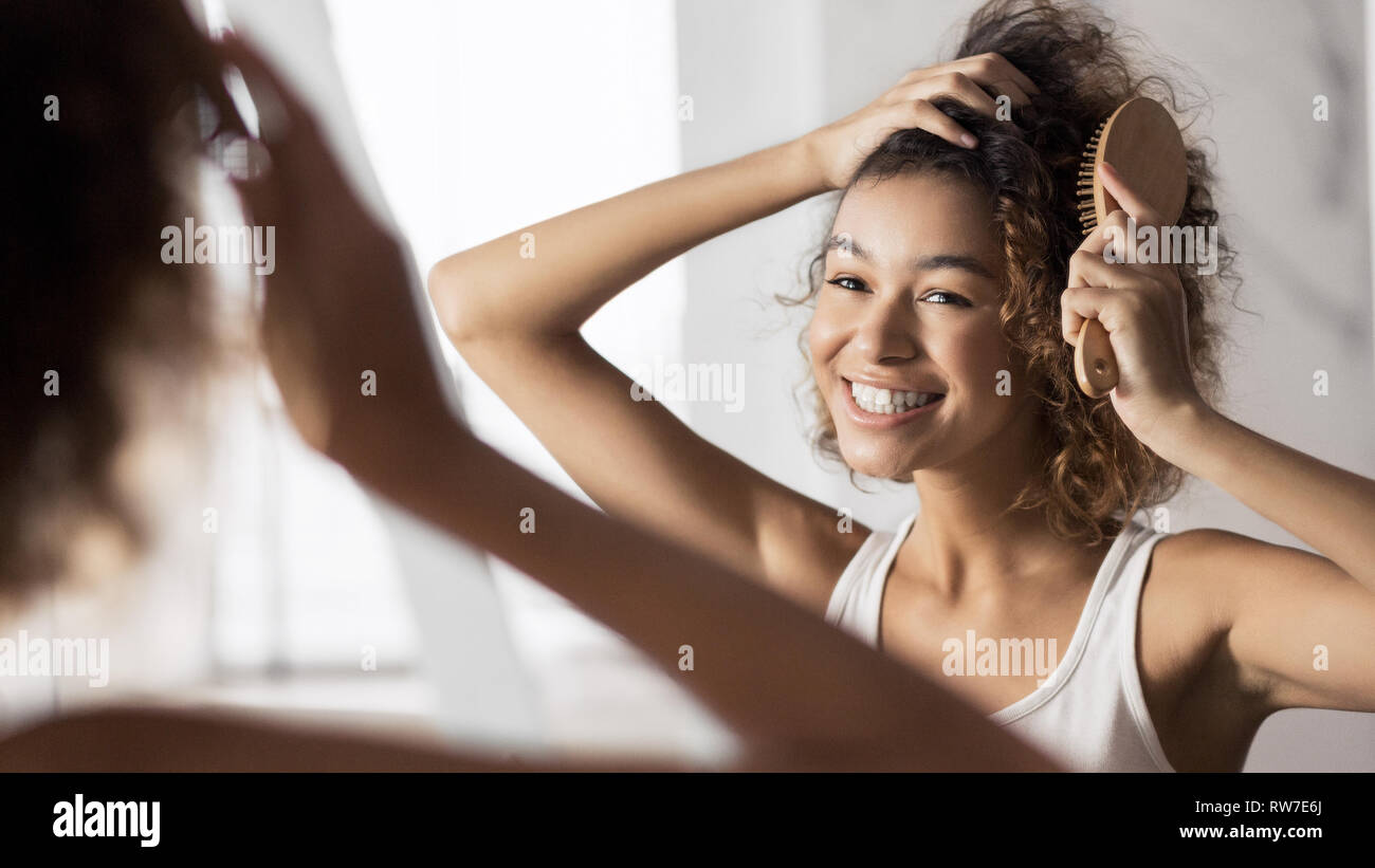 Combing wild curly hair concept Stock Photo - Alamy