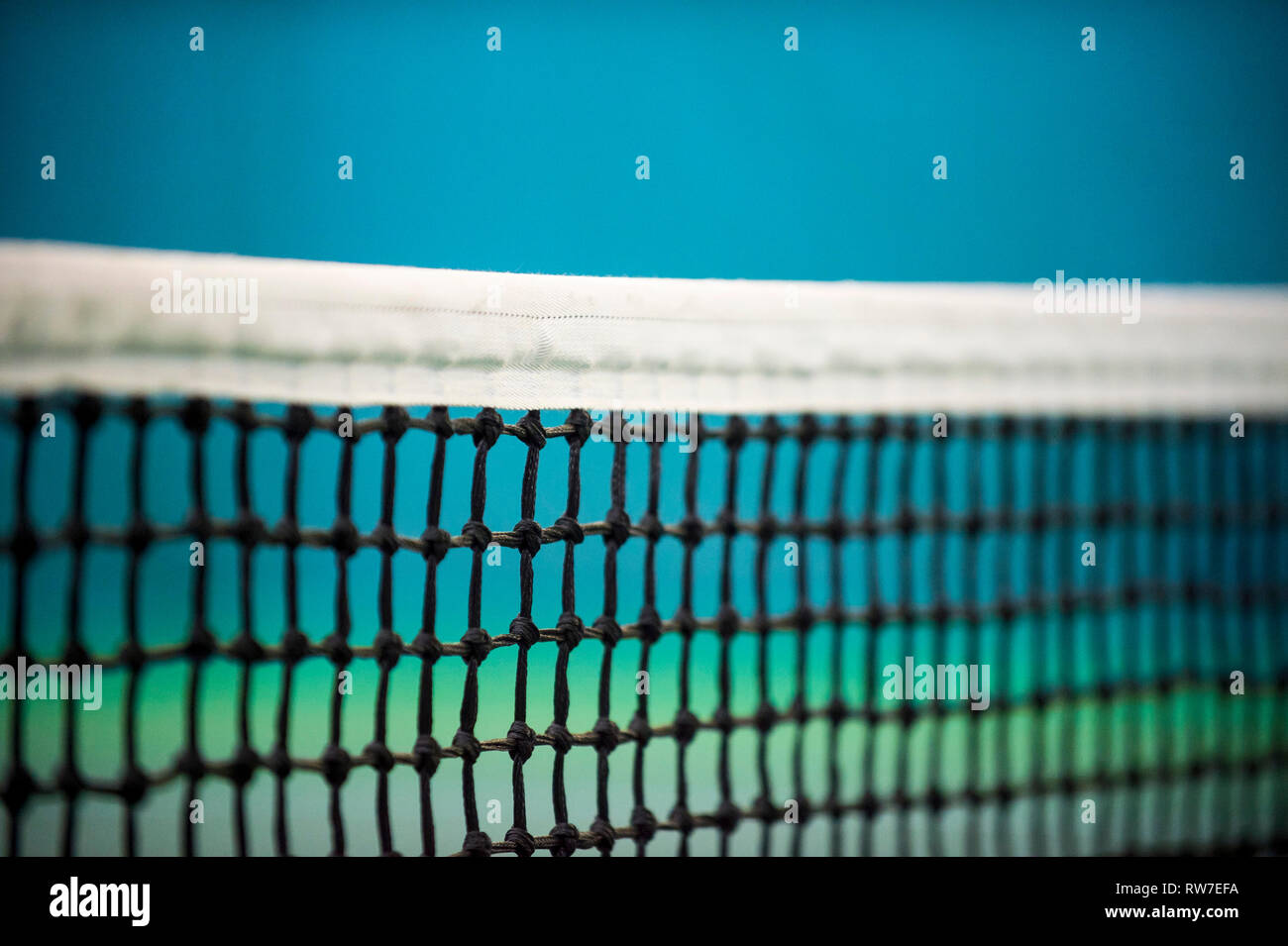 Net of tennis court on blue wall background Stock Photo - Alamy