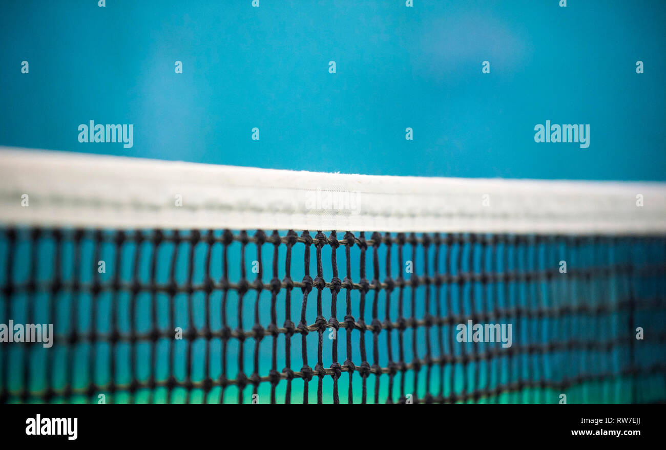 Net of tennis court on blue wall background Stock Photo - Alamy