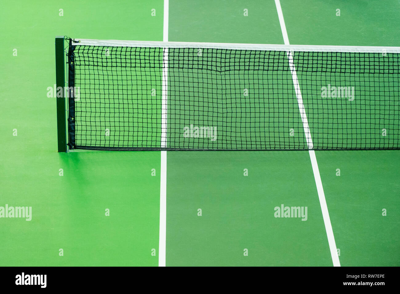 Net of tennis court on green wall background Stock Photo - Alamy