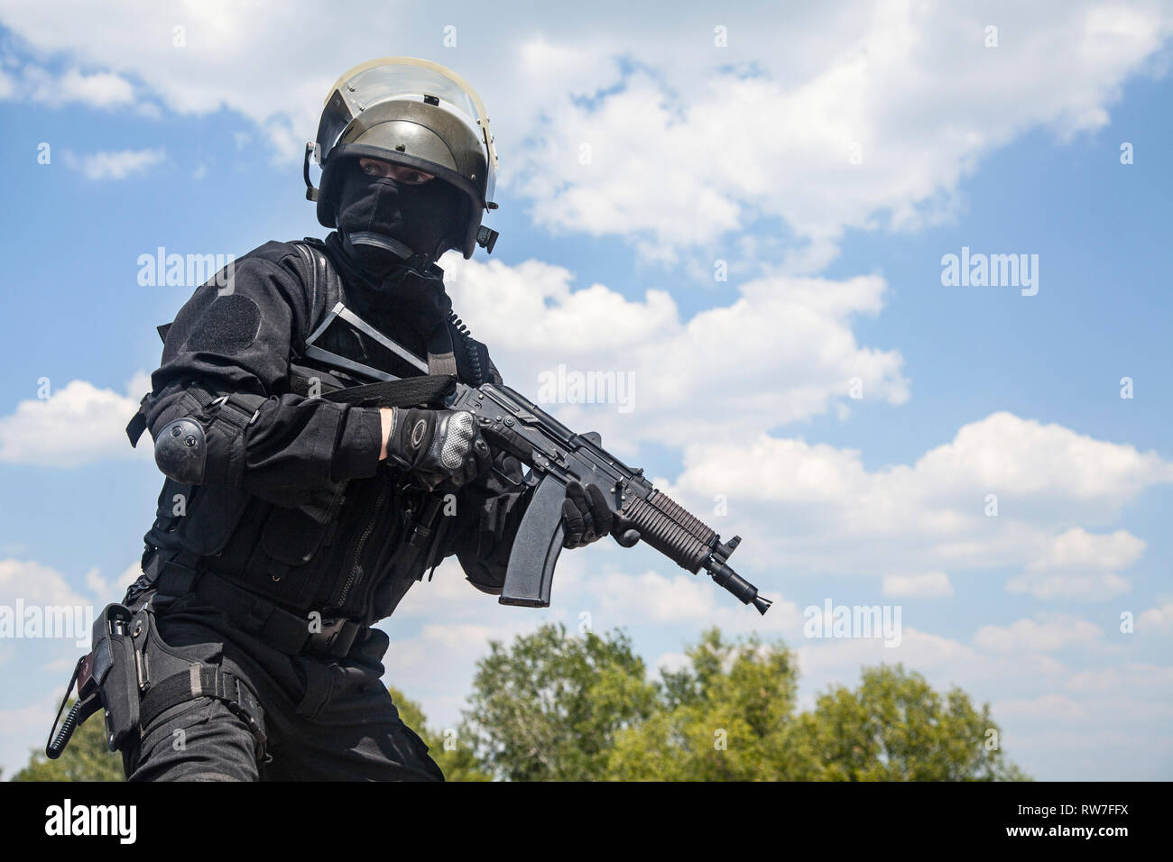 Spec ops soldier in black uniform and face mask with his rifle Stock ...