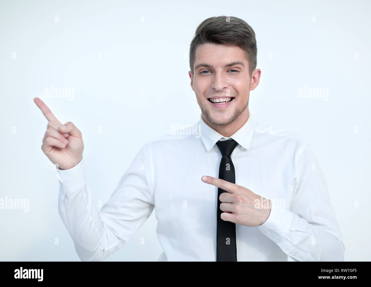 Smiling man pointing upwards and looking at camera Stock Photo - Alamy