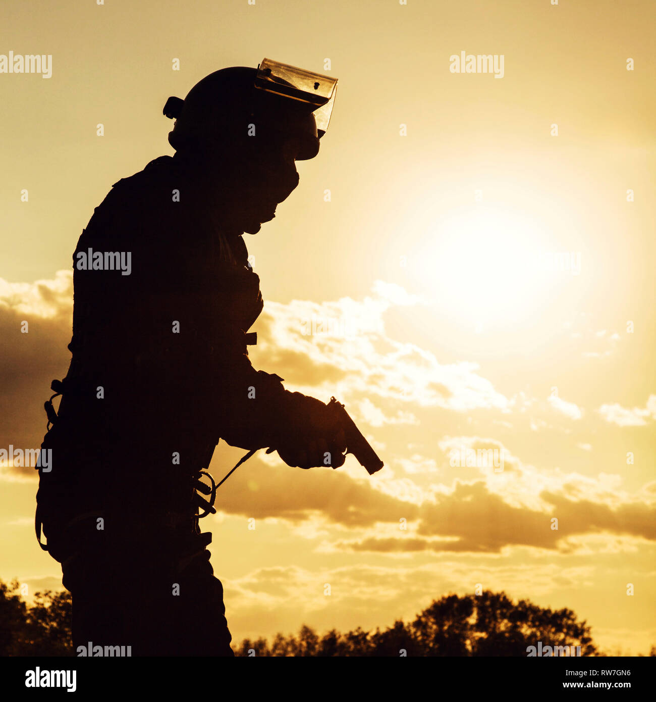 Silhouette of police officer with pistol at sunset Stock Photo - Alamy