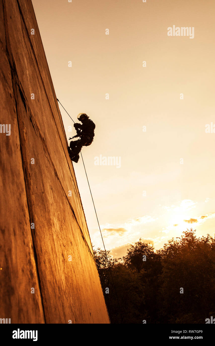 Silhouette of police officer during rope exercises with weapons Stock ...