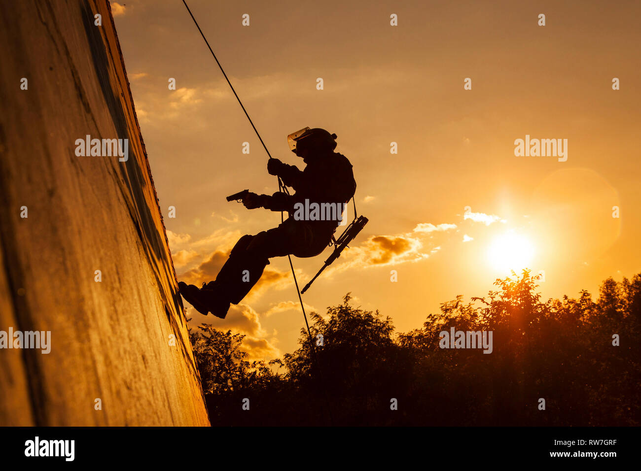 Silhouette of police officer during rope exercises with weapons Stock ...