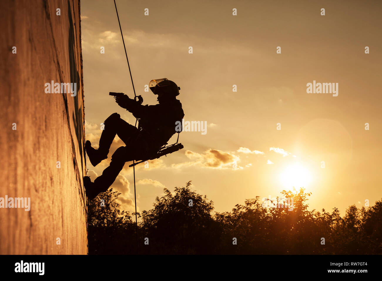 Silhouette of police officer during rope exercises with weapons Stock ...