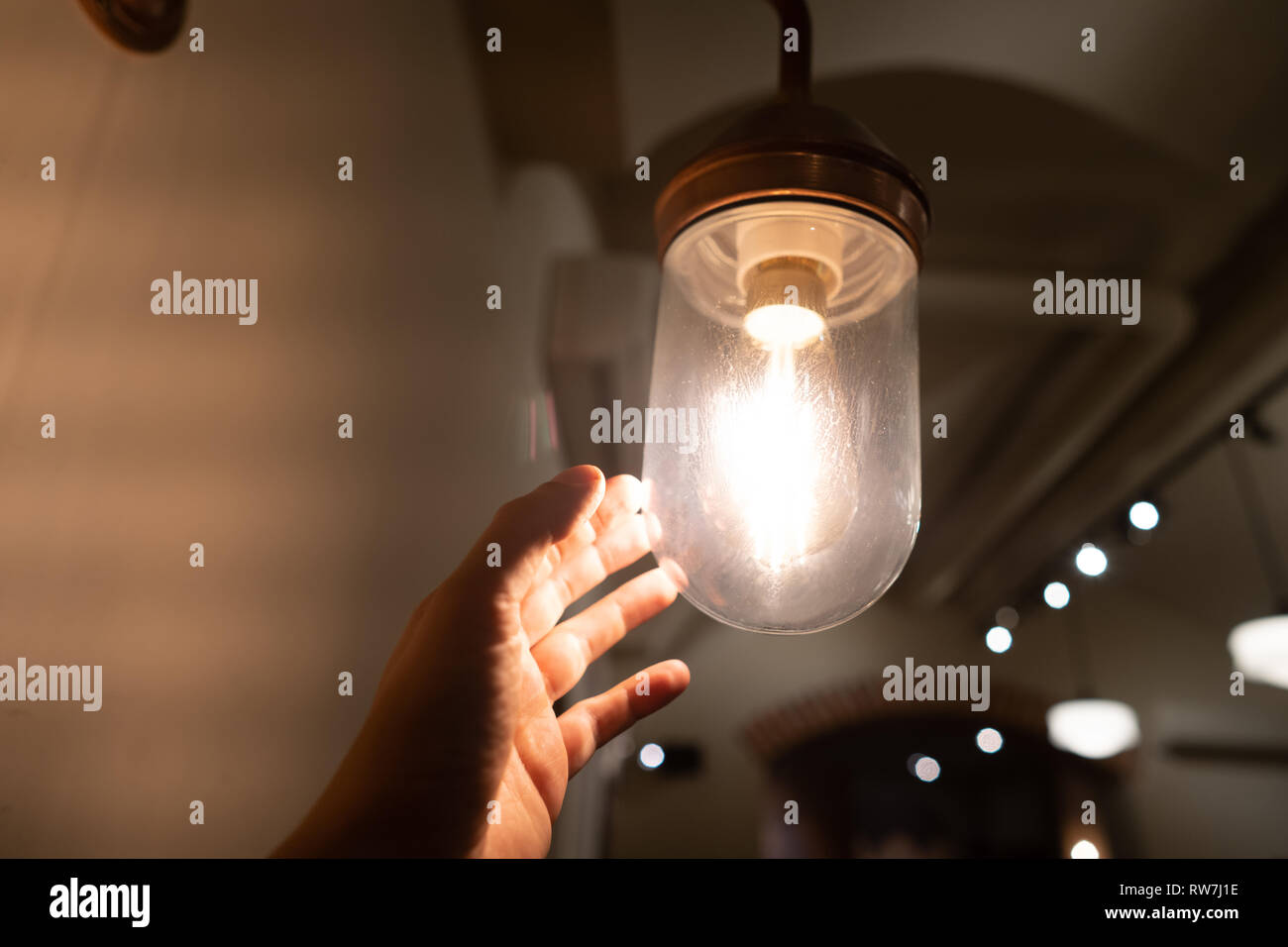 Hand reaching for a vintage light bulb Stock Photo - Alamy