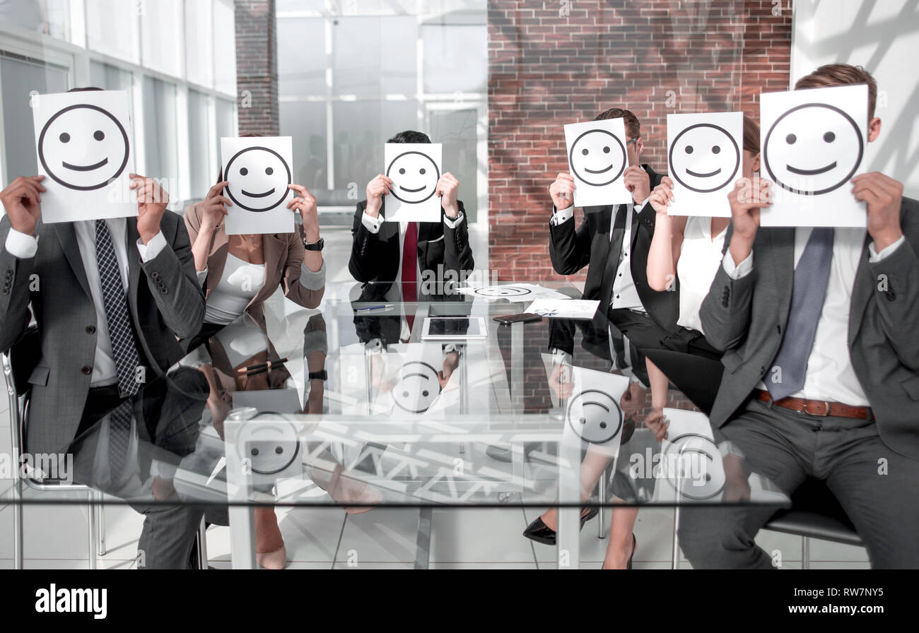 Business Team holding a paper with a positive smiley Stock Photo - Alamy