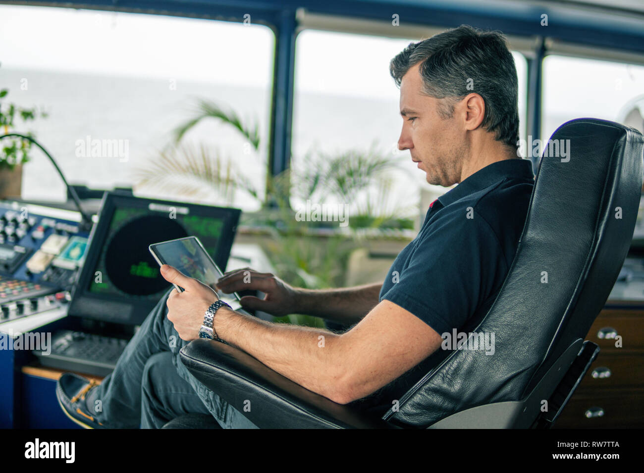 chief officer on navigation bridge watching digital tablet Stock Photo ...