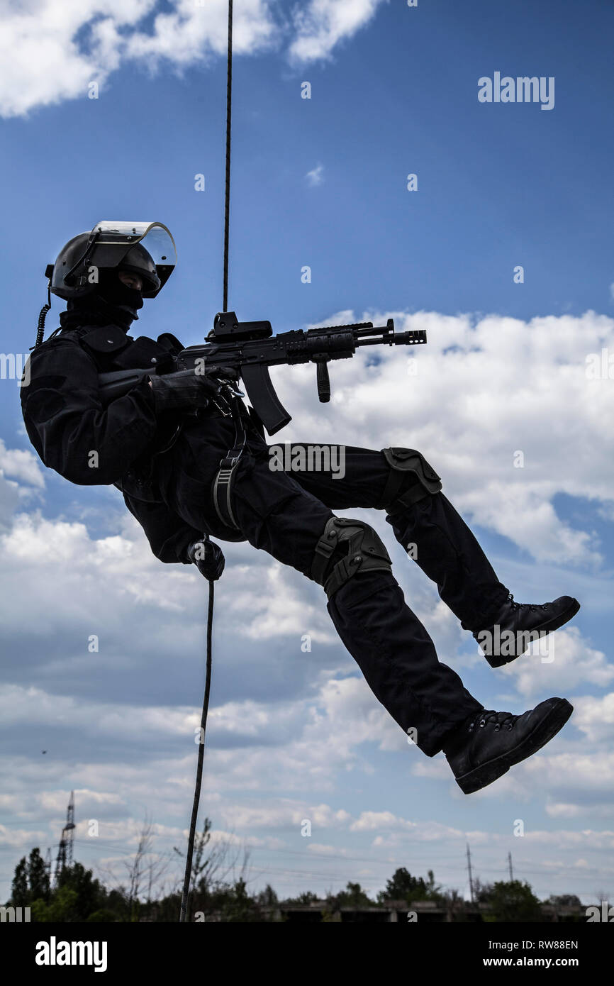 Special forces operator during assault rappelling with weapons Stock ...