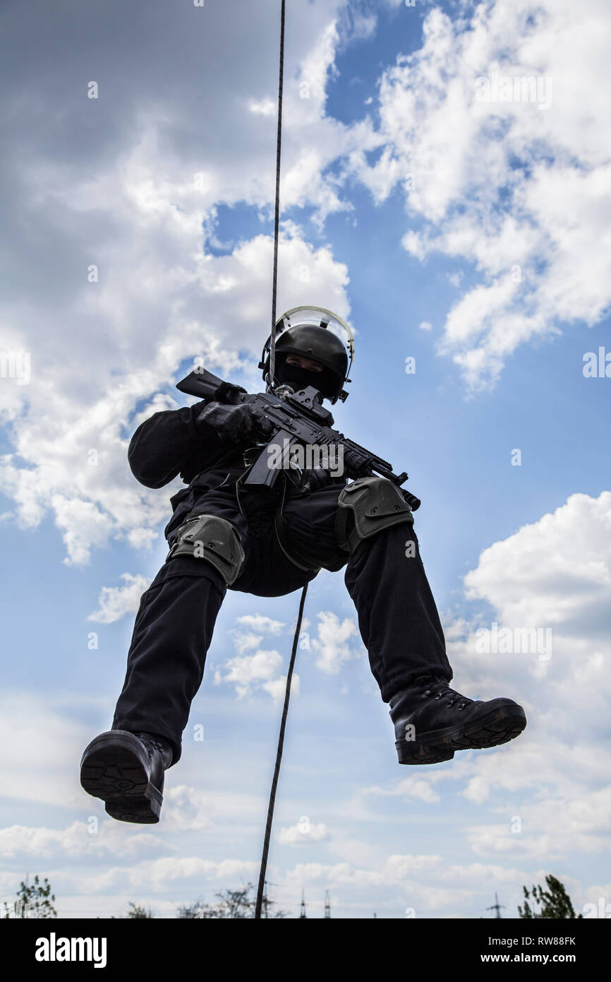 Special forces operator during assault rappelling with weapons Stock ...