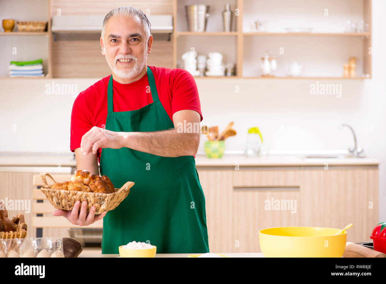 Old male baker working in the kitchen Stock Photo - Alamy
