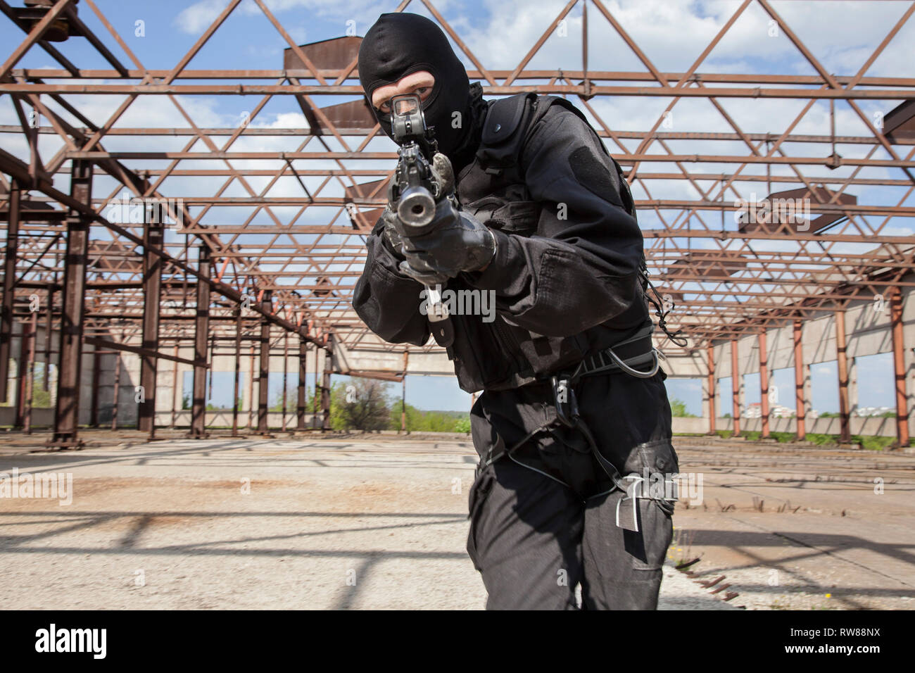 Special forces operator in black uniform in action Stock Photo - Alamy