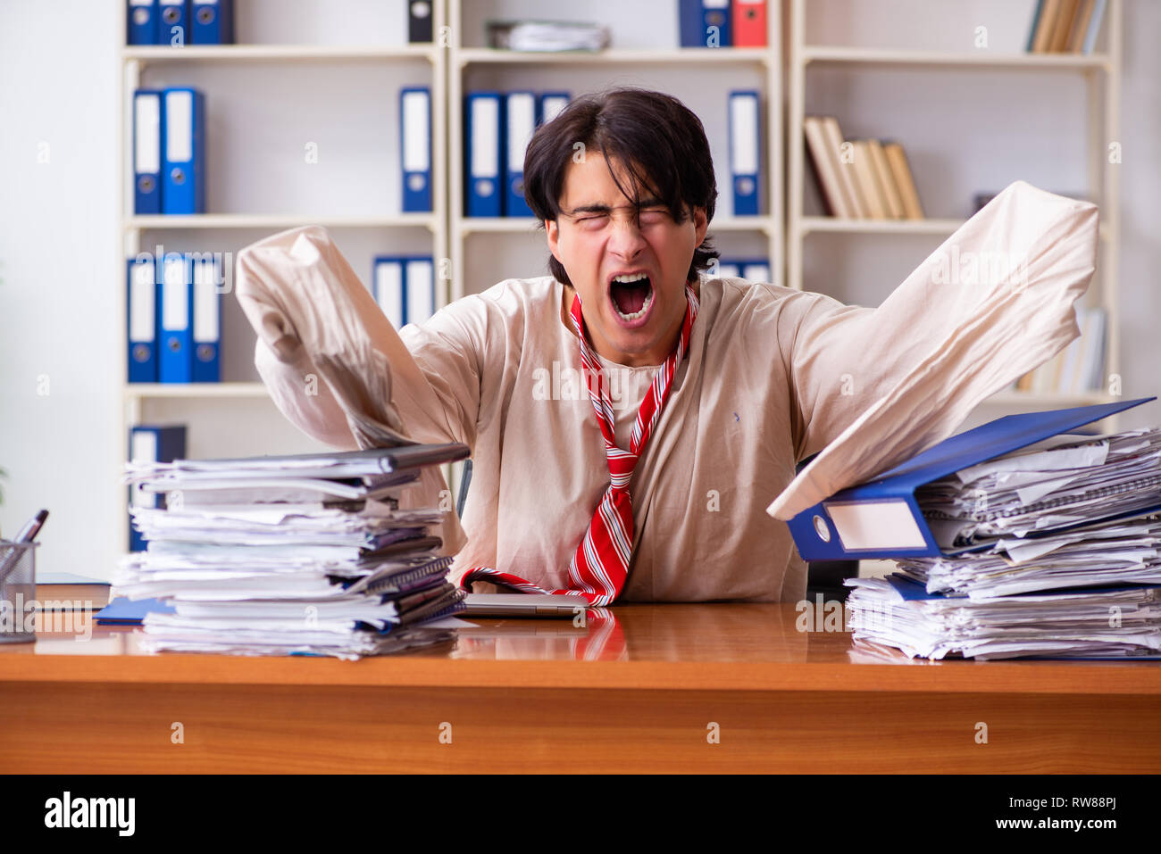 Crazy young man in straitjacket at the office Stock Photo - Alamy