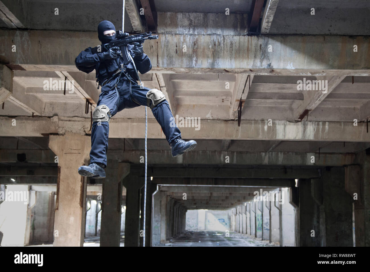 Special forces operator during assault rappelling with weapons Stock ...