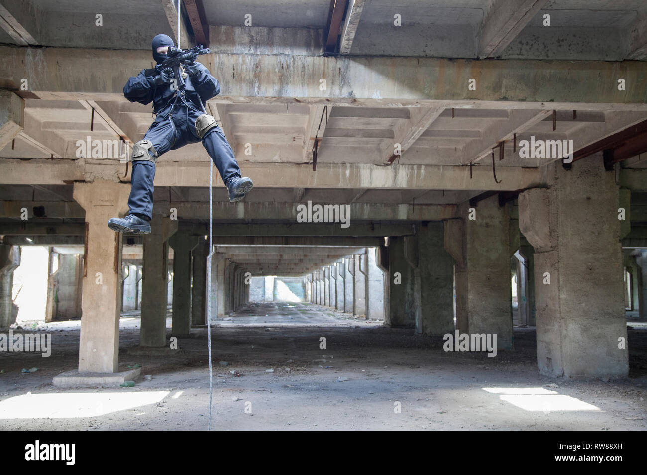 Special forces operator during assault rappelling with weapons Stock ...