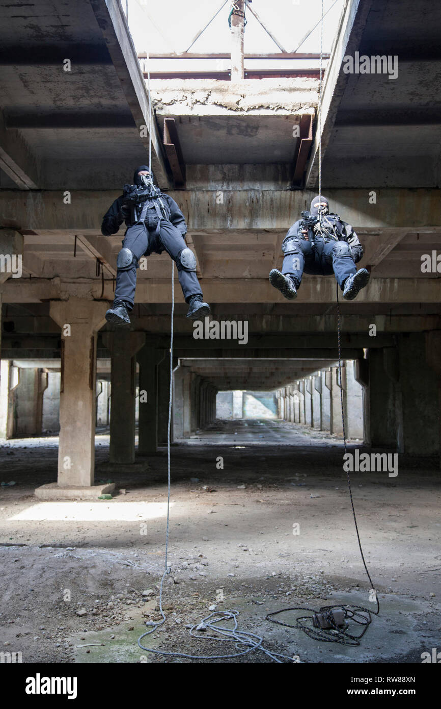 Special forces operators during assault rappelling with weapons Stock ...