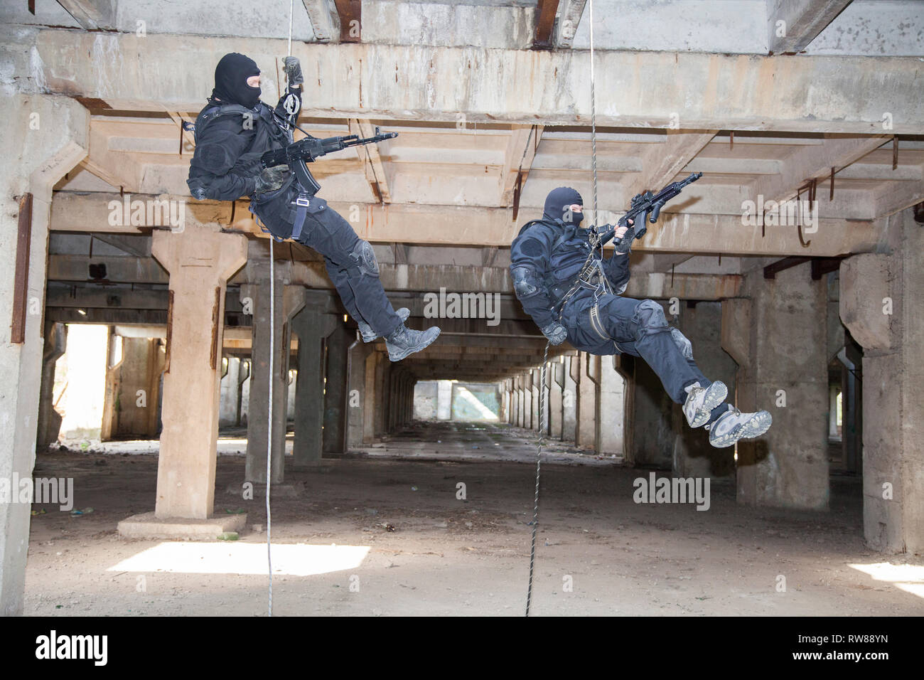 Special forces operators during assault rappelling with weapons Stock ...